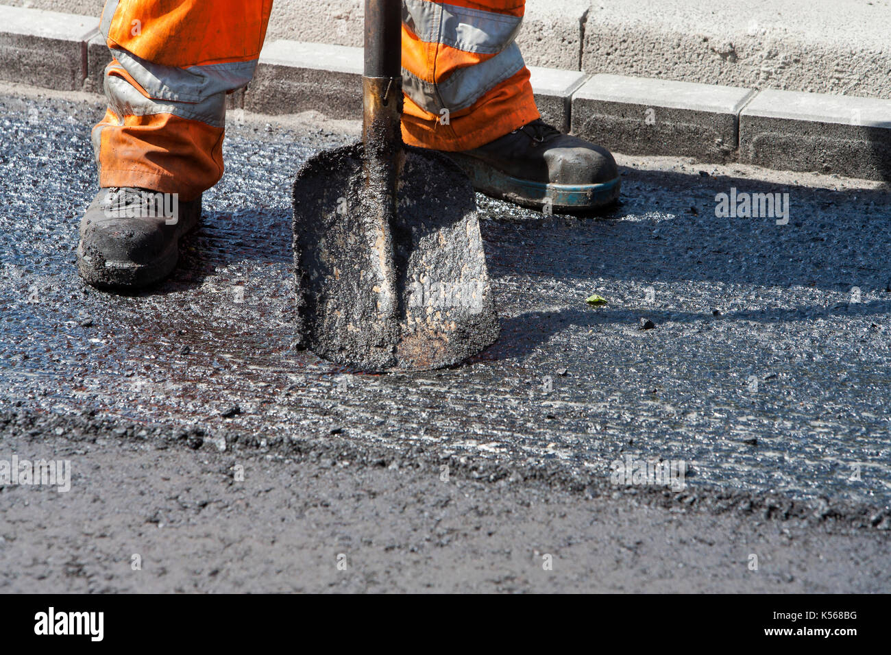 Manual asphalt worker with his shovel Stock Photo - Alamy