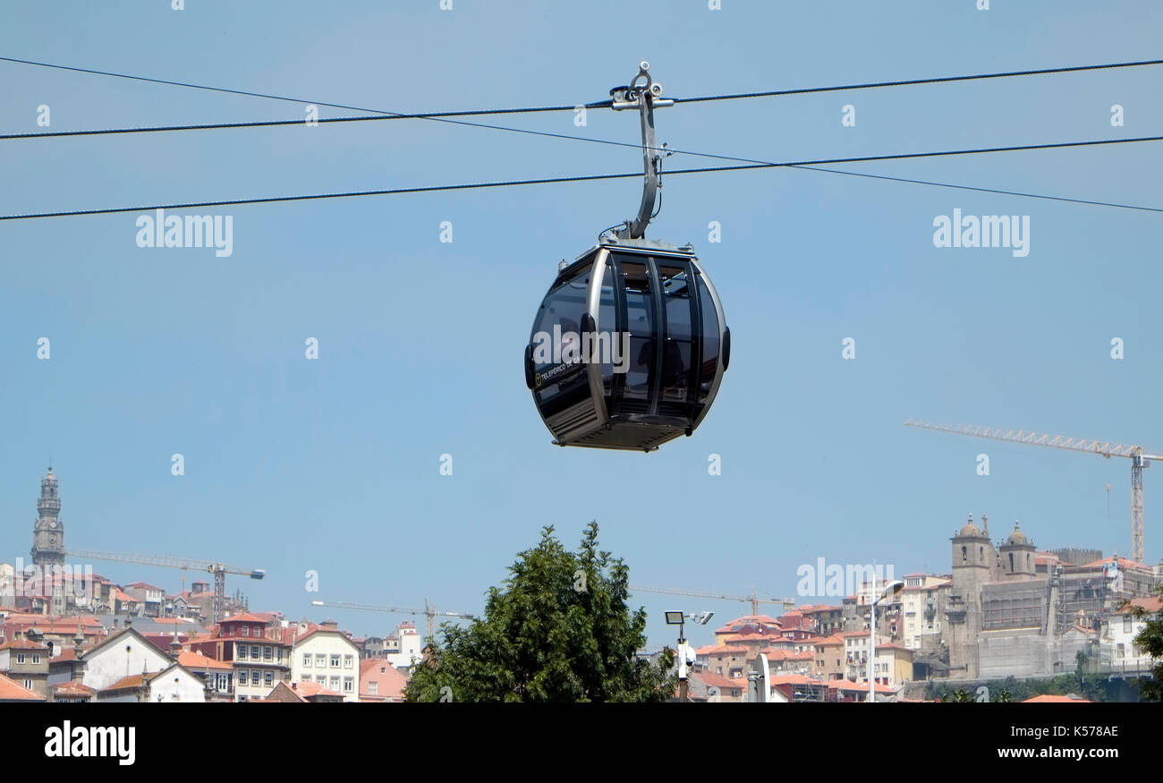 Tourists ride in gondolas on the Teleferico de Gaia cable car above the ...