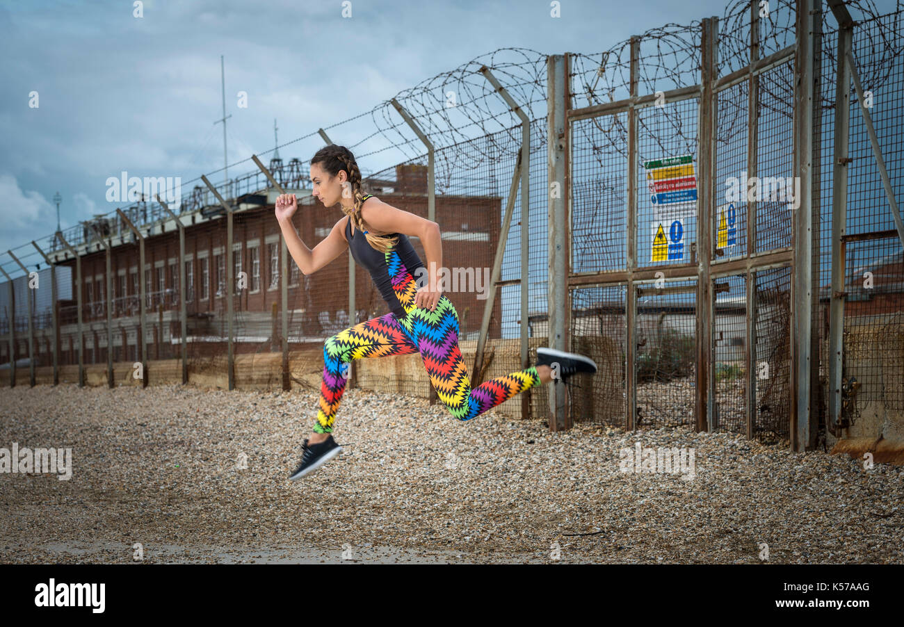 fit woman wearing colourful sportswear running and jumping, keeping fit ...