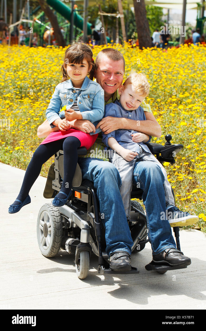 Disabled father play with his little son and daughter Stock Photo - Alamy