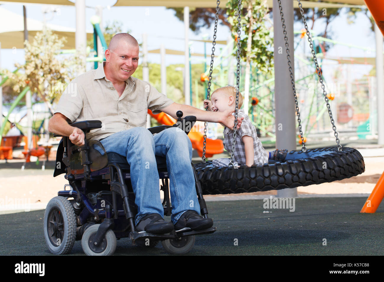 Disabled Father play with his little son on the playground Stock Photo ...