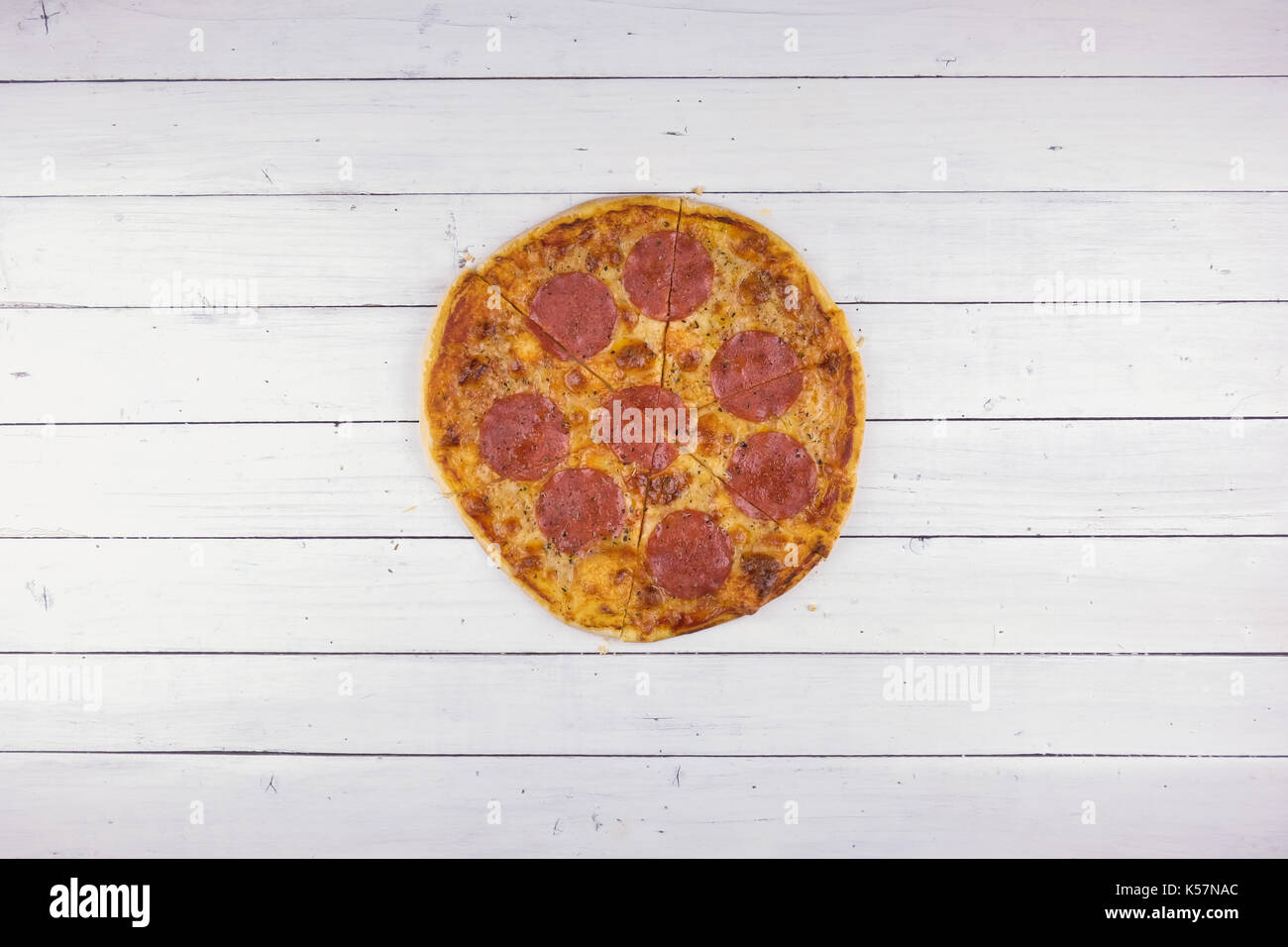Top view of baking pepperoni pizza on white wood background Stock Photo ...