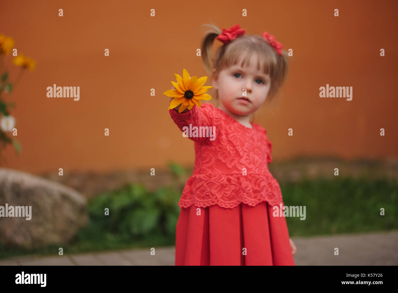 happy little girl with yellow flowers Stock Photo - Alamy
