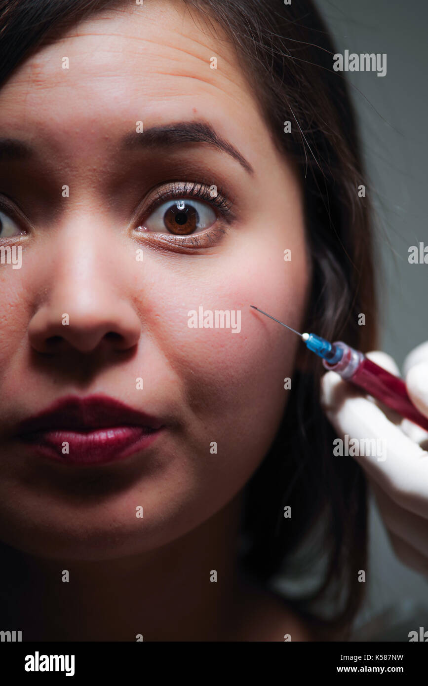 Portrait of a scary beautiful woman, with a needle injection treatment ...