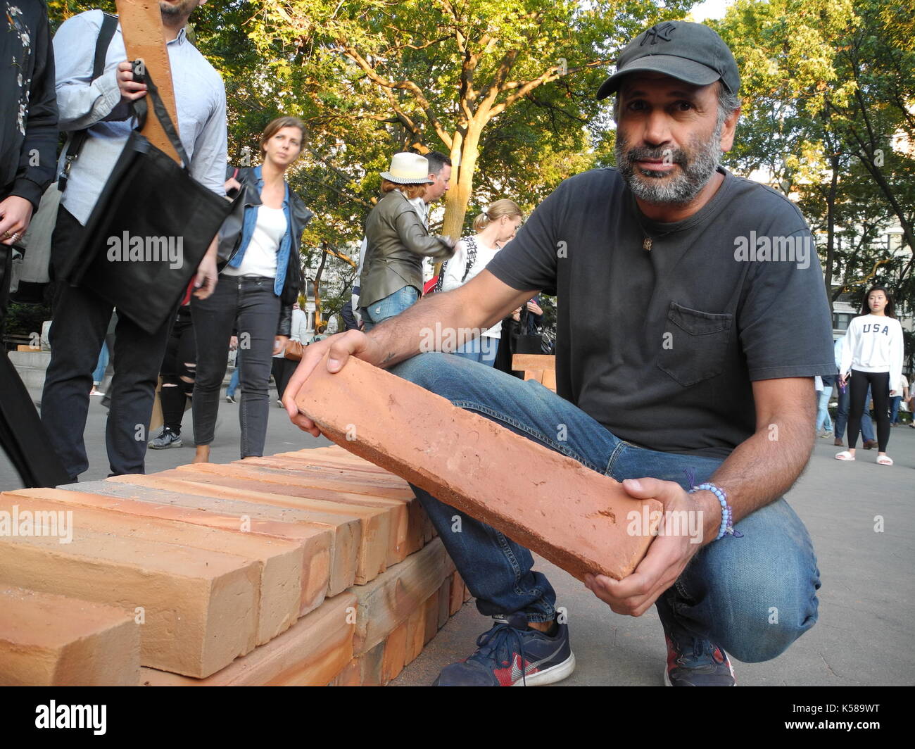 Mexican artist Bosco Sodi holds a brick of his project "El Muro", which ...