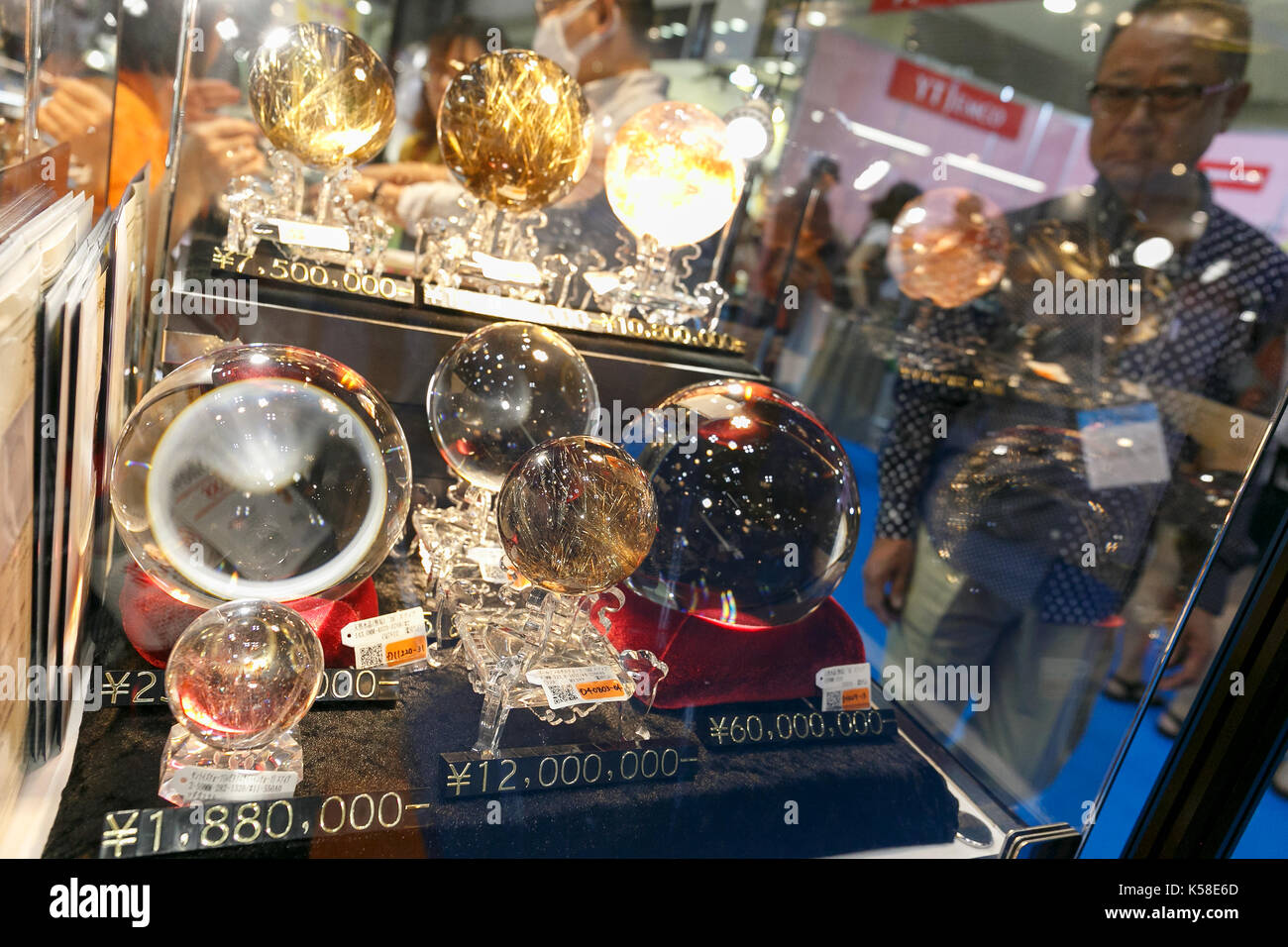 A man looks at the rock crystal balls on display at the Tokyo ...