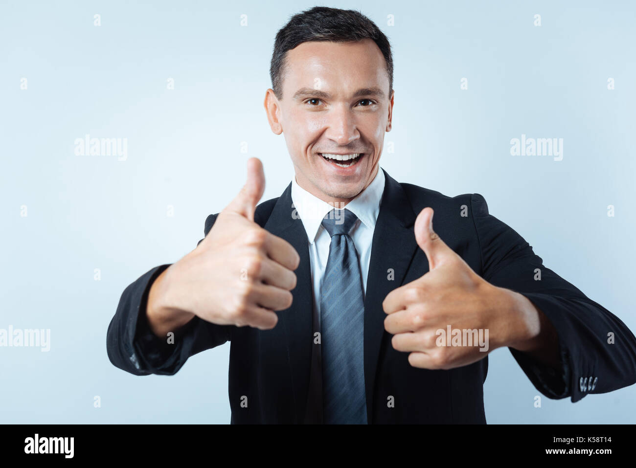 Joyful positive man showing thumbs up gestures Stock Photo - Alamy