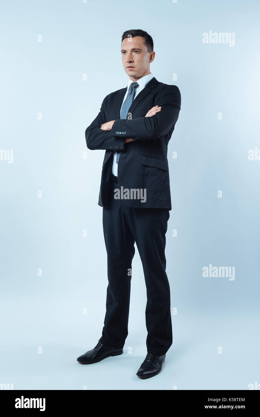 Serious nice man standing against blue background Stock Photo - Alamy