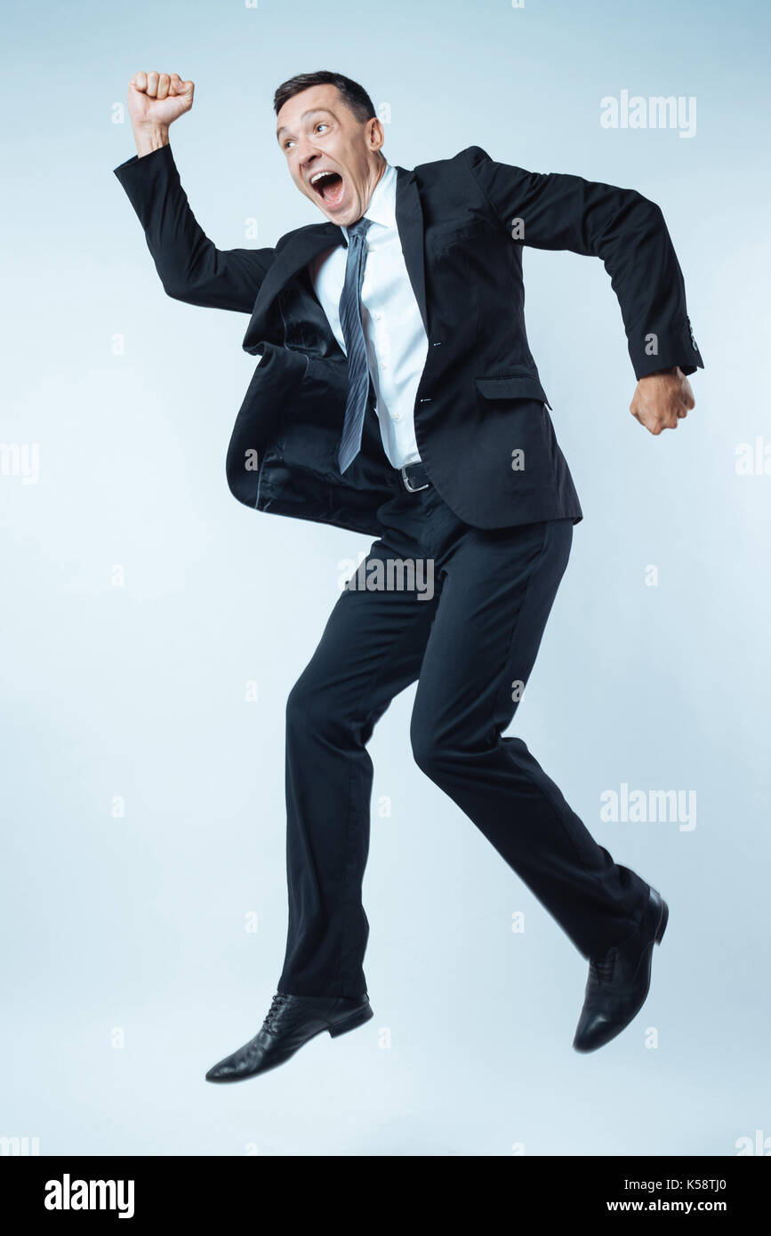 Delighted emotional man jumping Stock Photo - Alamy