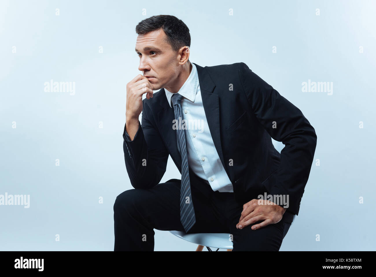 Thoughtful smart man sitting on the chair Stock Photo - Alamy