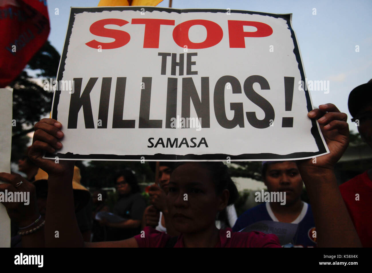 A protester holds a placard during a rally against extrajudicial ...