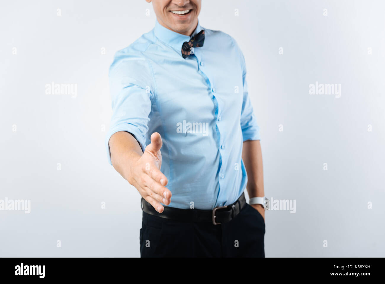 Positive friendly man giving his hand Stock Photo - Alamy