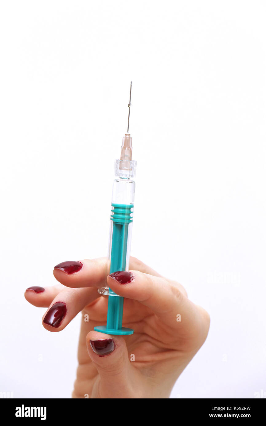 Medical syringe with needle in female hand Stock Photo - Alamy