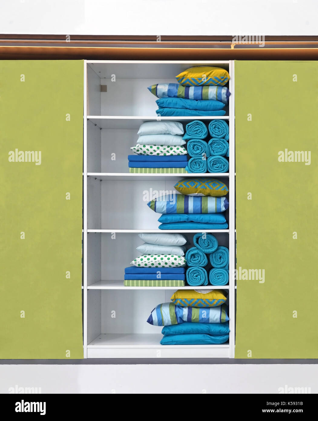 Open closet with stacks of blue home accessories on shelves Stock Photo ...