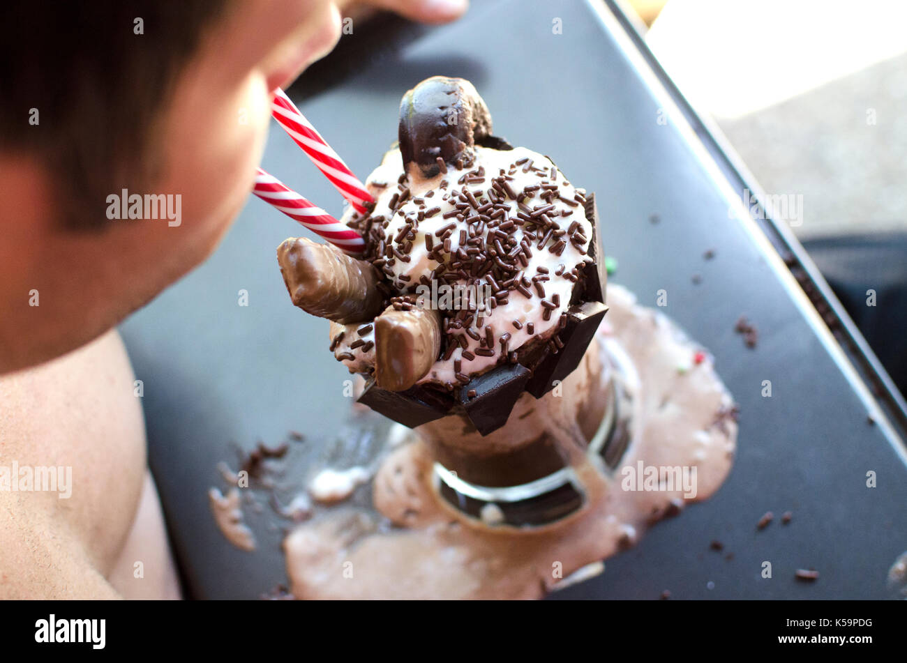 Guy drinking melting chocolate milkshake out of glass for summer ...