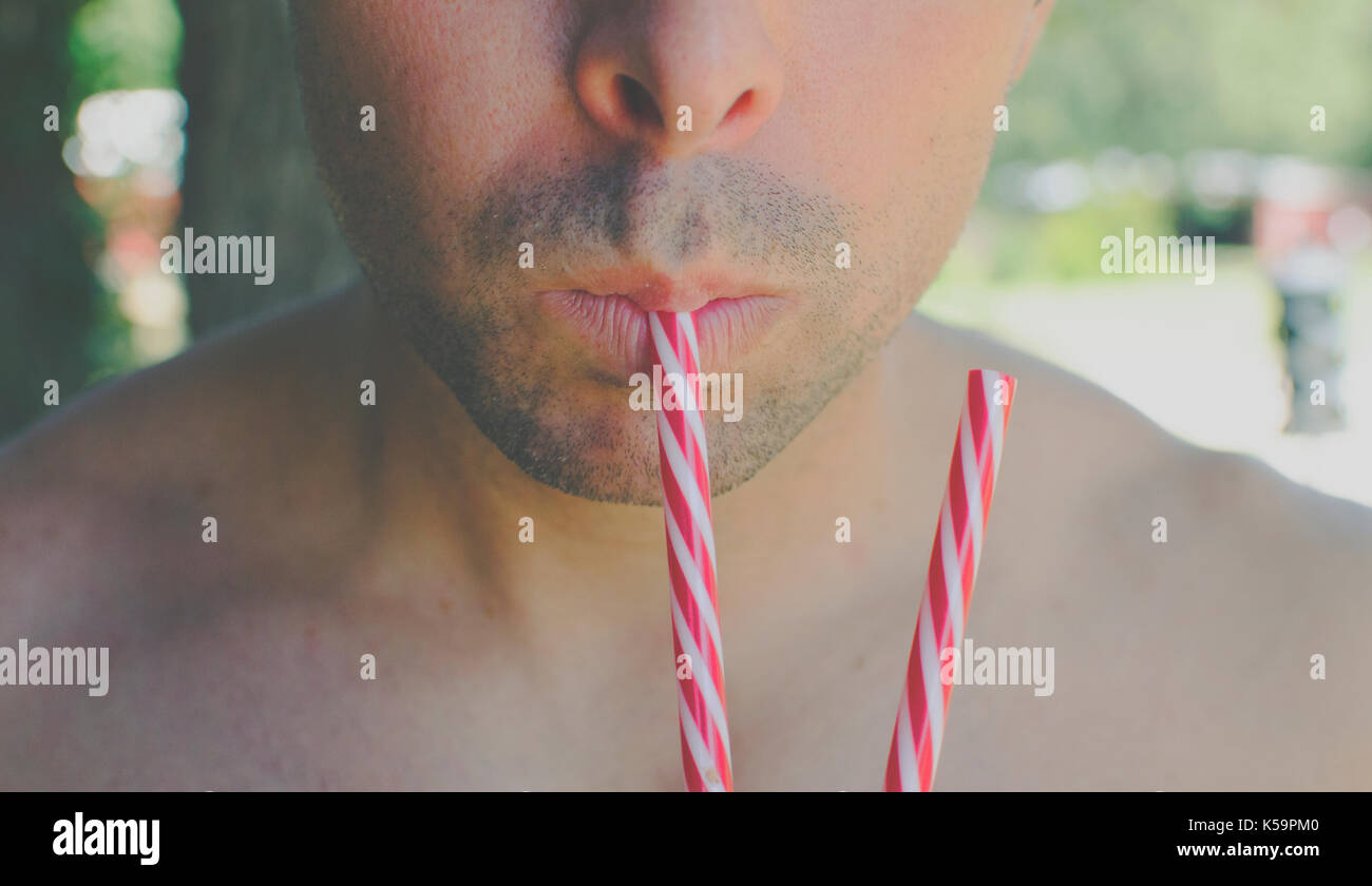 Man drinking shake through red striped straws without a shirt Stock ...
