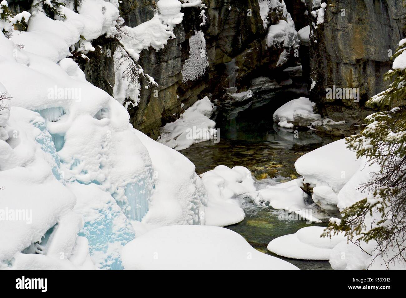 Glacial blue ice formations around rock and stream at Marble Canyon in ...
