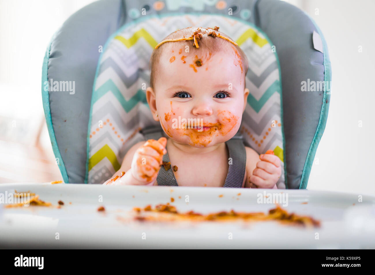 Little baby eating her dinner and making a mess Stock Photo - Alamy