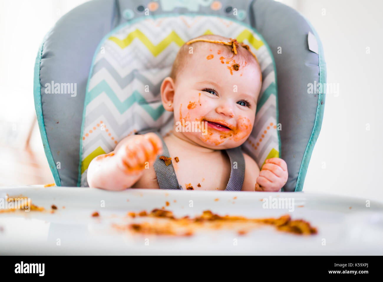 Little baby eating her dinner and making a mess Stock Photo - Alamy