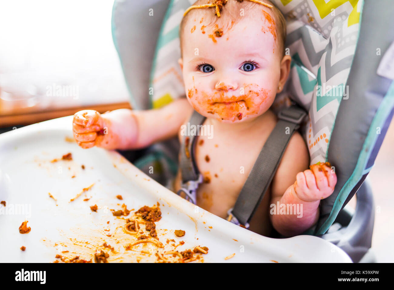 Little baby eating her dinner and making a mess Stock Photo - Alamy