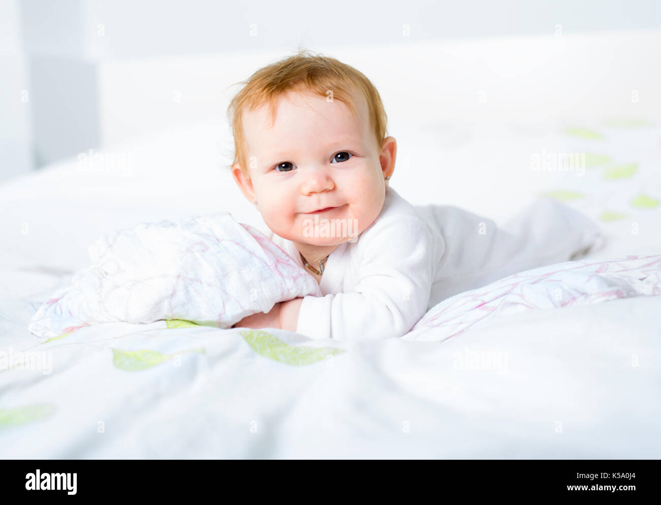 Portrait of a crawling baby on the bed in her room Stock Photo - Alamy