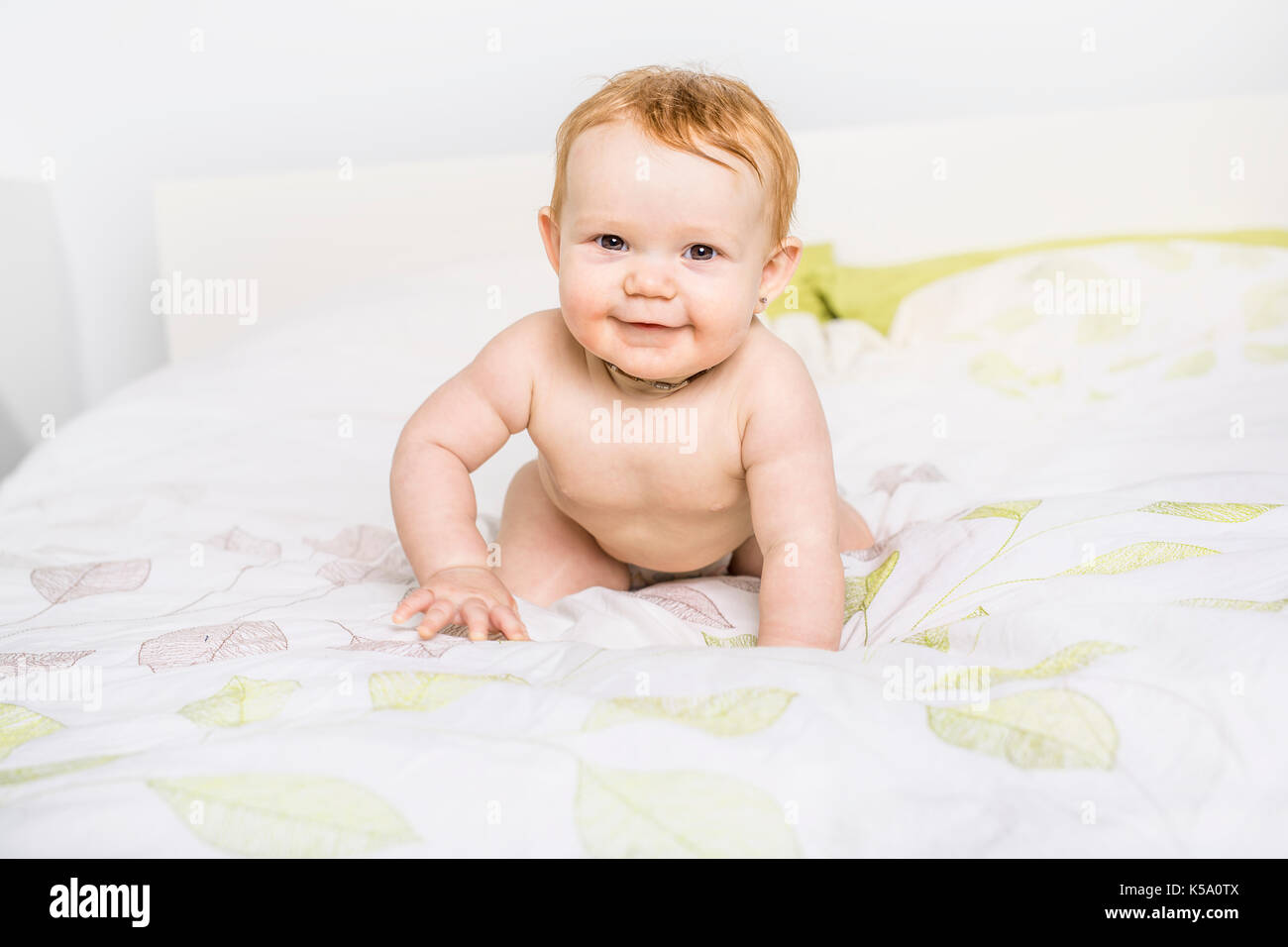 Portrait of a crawling baby on the bed in her room Stock Photo - Alamy