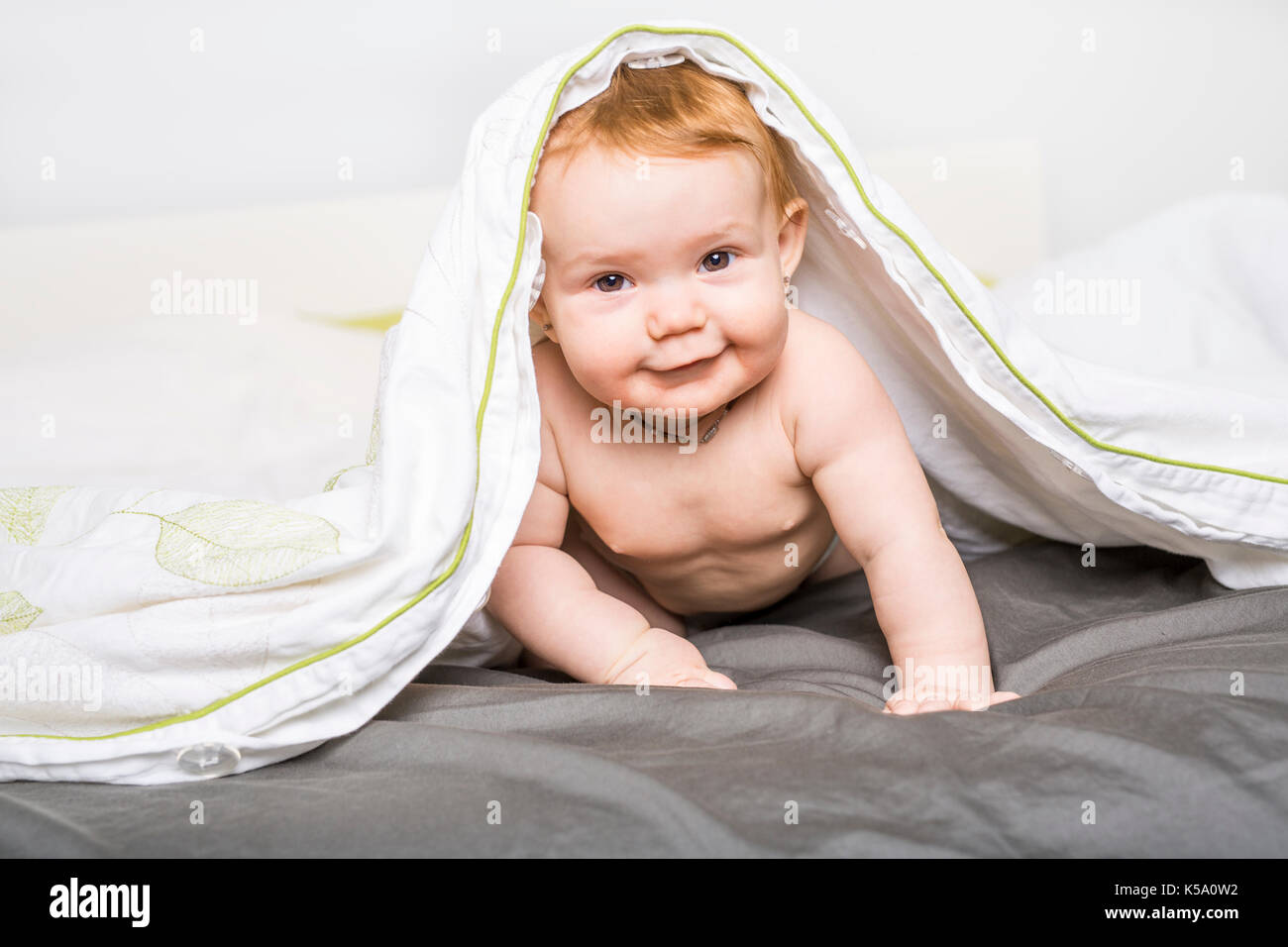 Portrait of a crawling baby on the bed in her room Stock Photo - Alamy