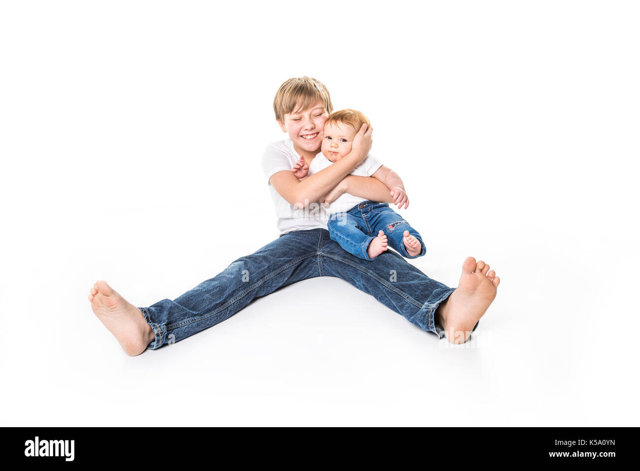 portrait of child little boy holding baby on studio white background ...