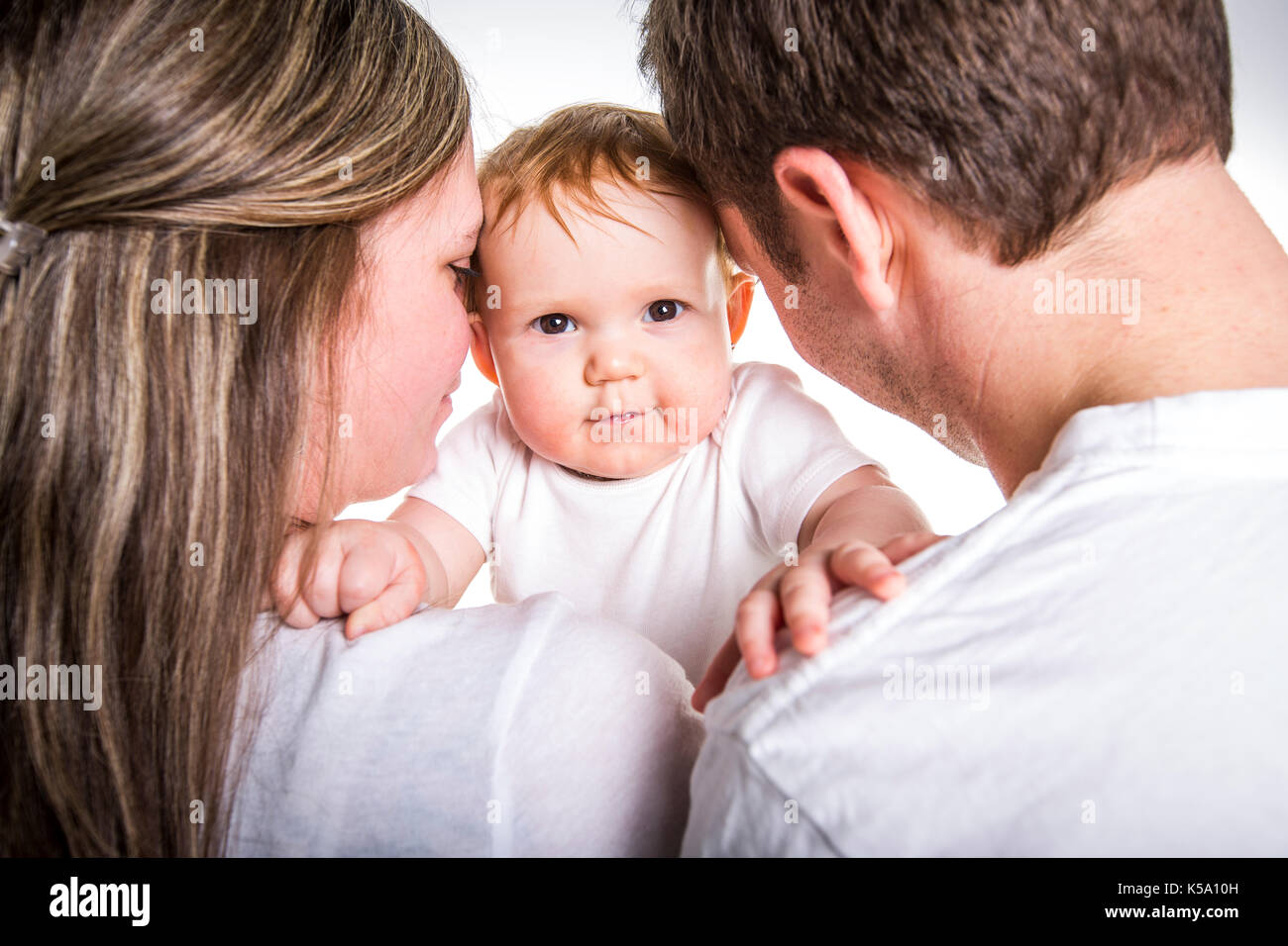 Happy young family with baby in studio white background Stock Photo - Alamy