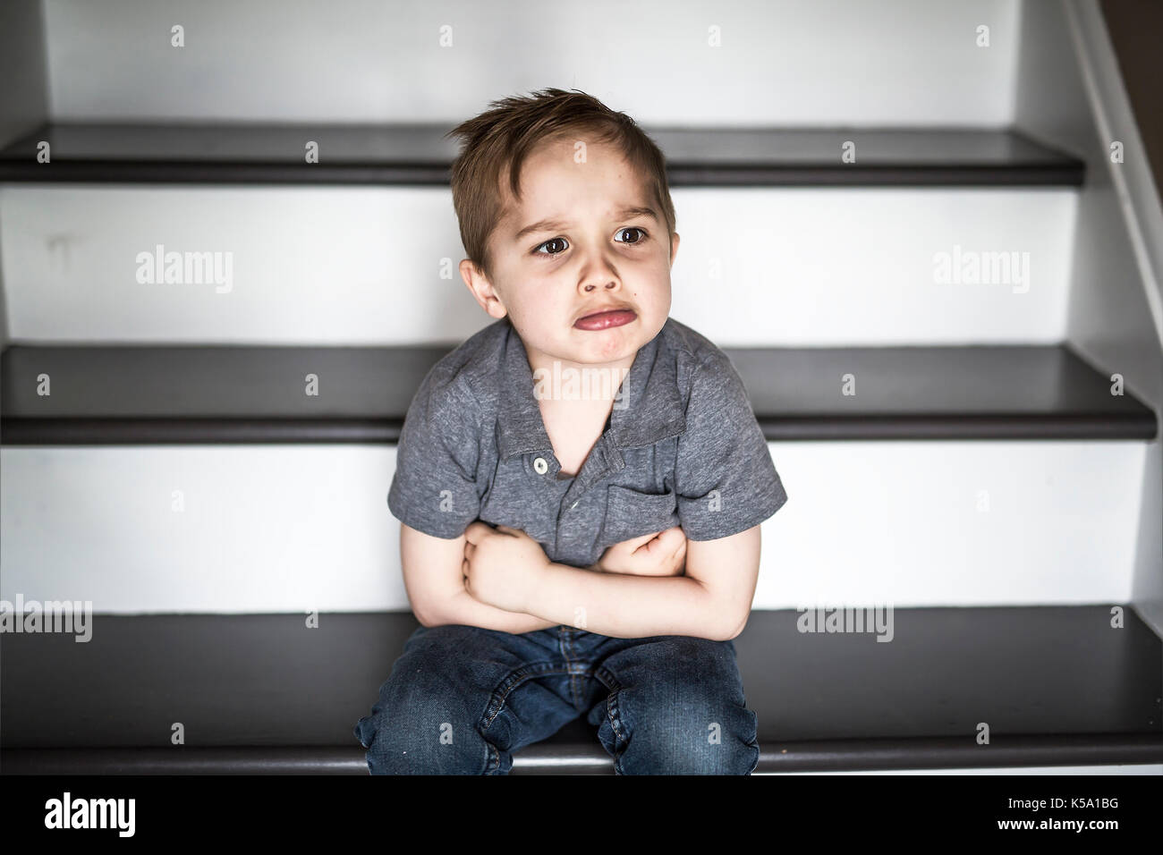 Sad boy sitting on stairs hi-res stock photography and images - Alamy