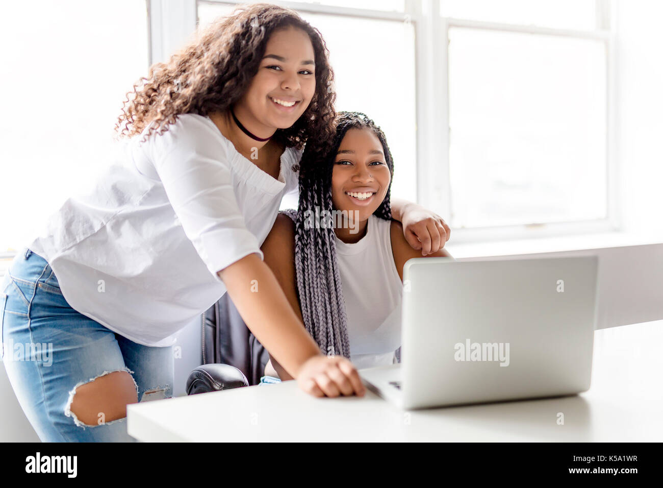 Two teen at desk in her office with laptop Stock Photo - Alamy