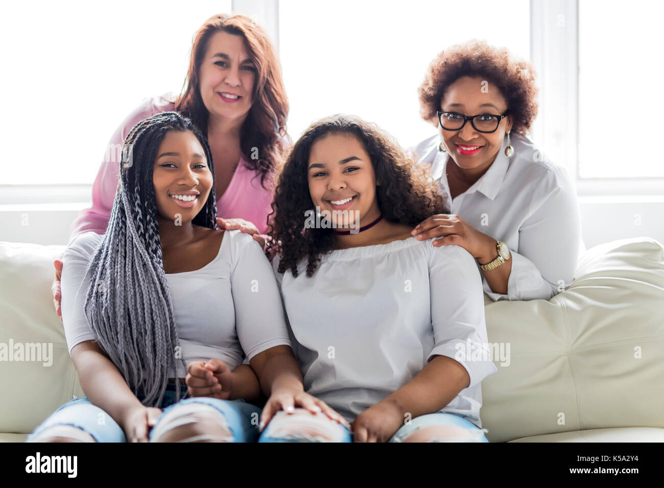 Two family Friends Sitting On Sofa Together Stock Photo - Alamy