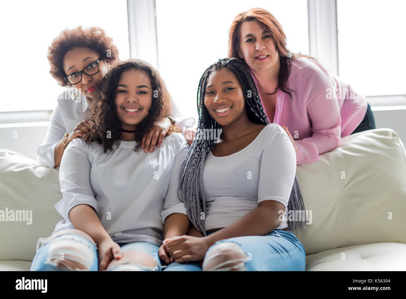 Two family Friends Sitting On Sofa Together Stock Photo - Alamy