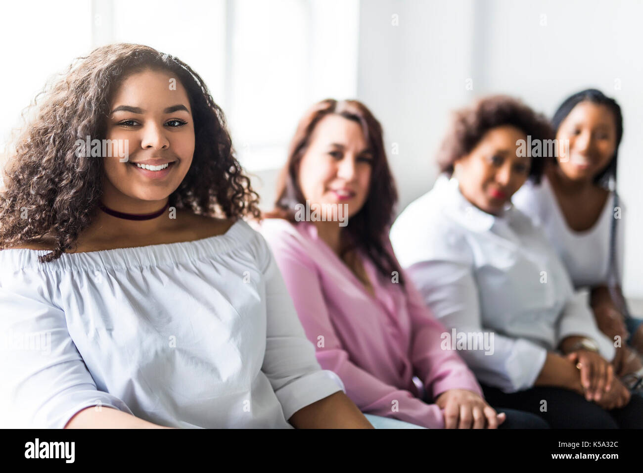 Two family Friends Sitting On Sofa Together Stock Photo - Alamy