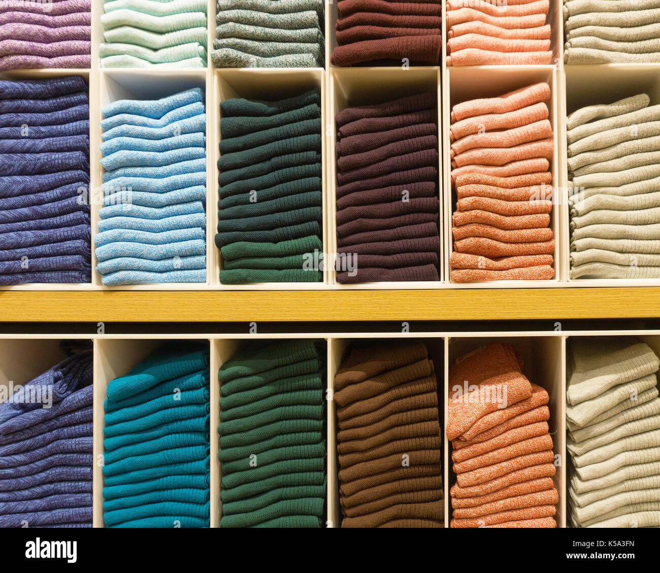 Stack Of Sweaters Displayed On Rack Stock Photo - Alamy