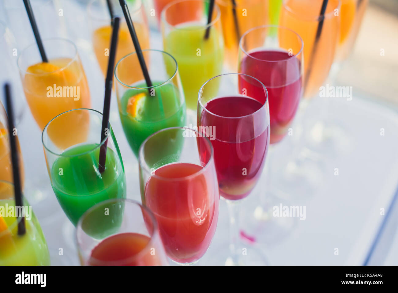 Beautiful line of different coloured cocktails on a open air party ...