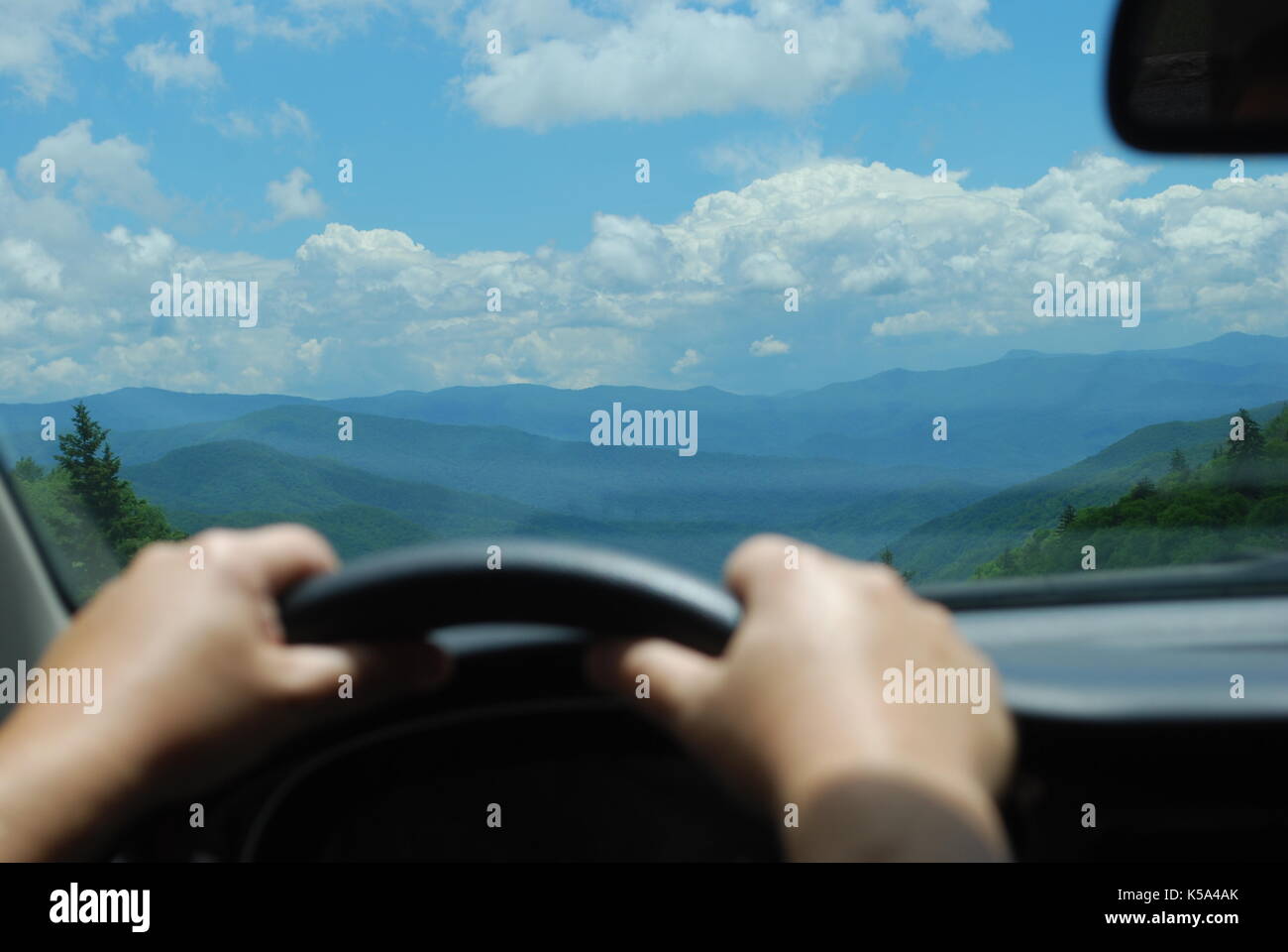 Fantastic view through the car front window on mountains with blue sky ...