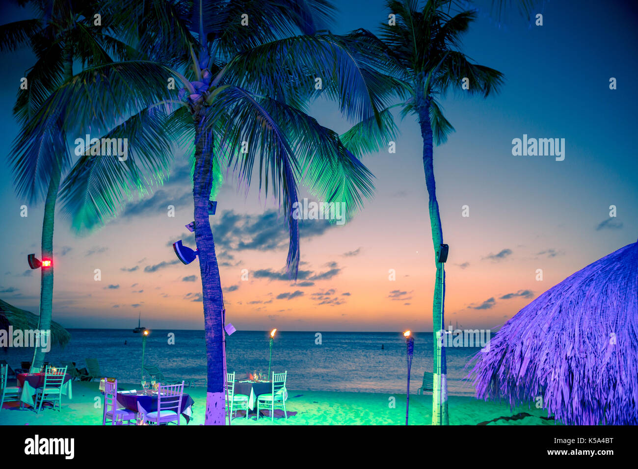 Tropical Beach Evening with palm trees and dining Stock Photo - Alamy