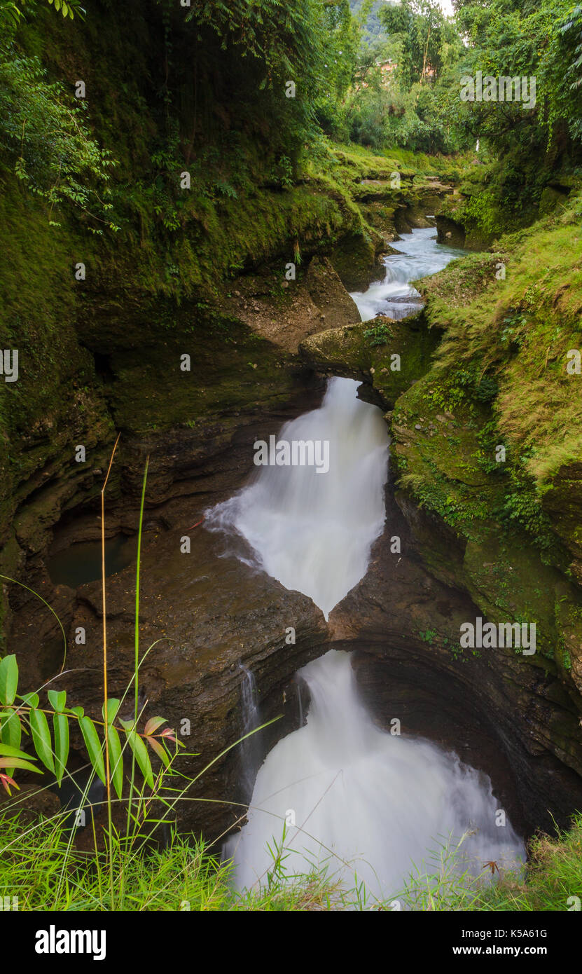 Water flows down Devi's Falls into the Gupteshwar Cave below in Pokhara ...