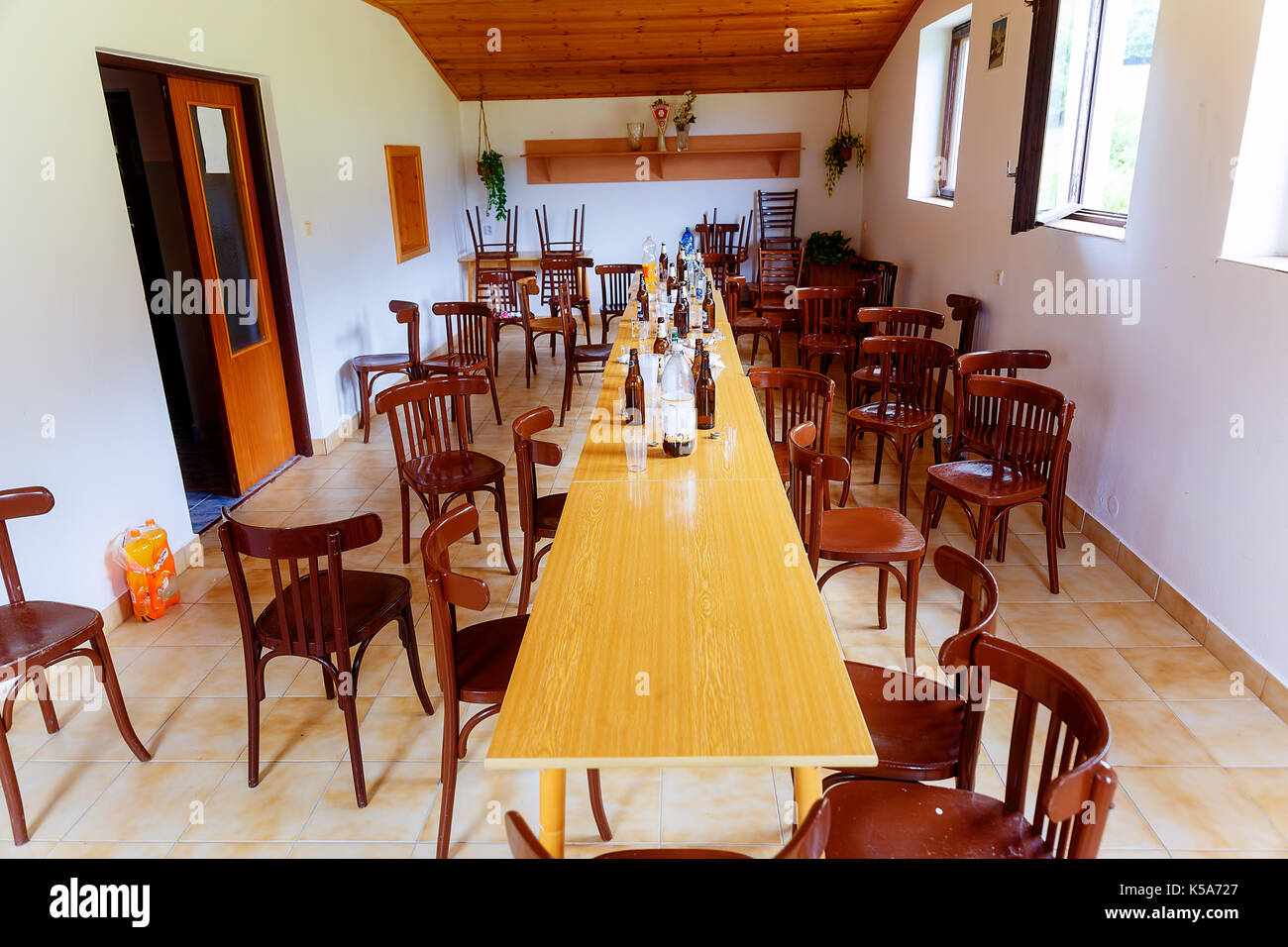 abandoned room with chairs, tables and and empty bottles after party ...
