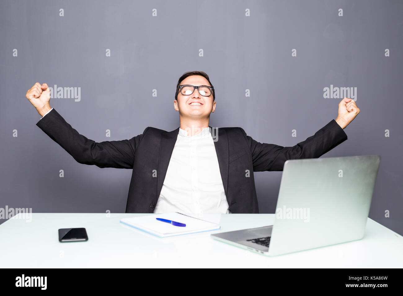 Happy man completed task and triumphing with raised hands Stock Photo ...