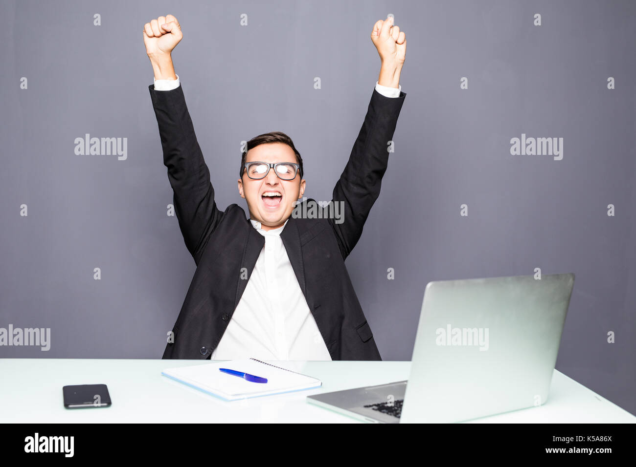 Happy man completed task and triumphing with raised hands Stock Photo ...