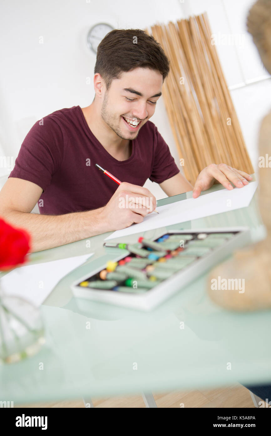 young man drawing pictures in studio Stock Photo - Alamy