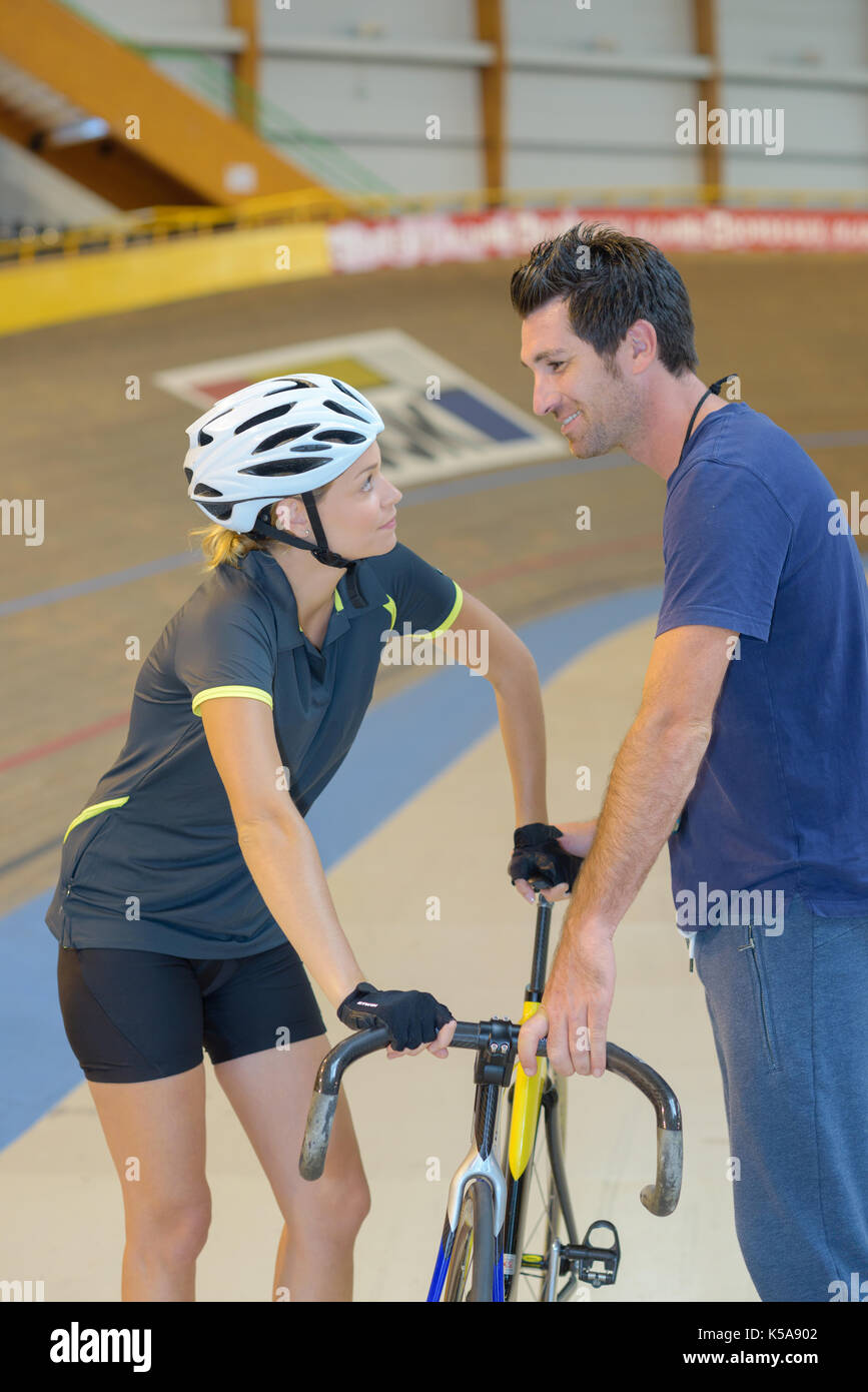 woman and coach cycling at track Stock Photo - Alamy