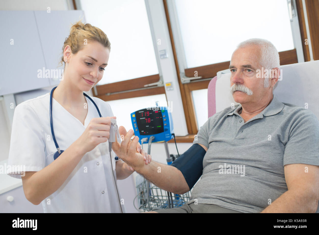 female doctor showing putting a finger prick device on patient Stock ...