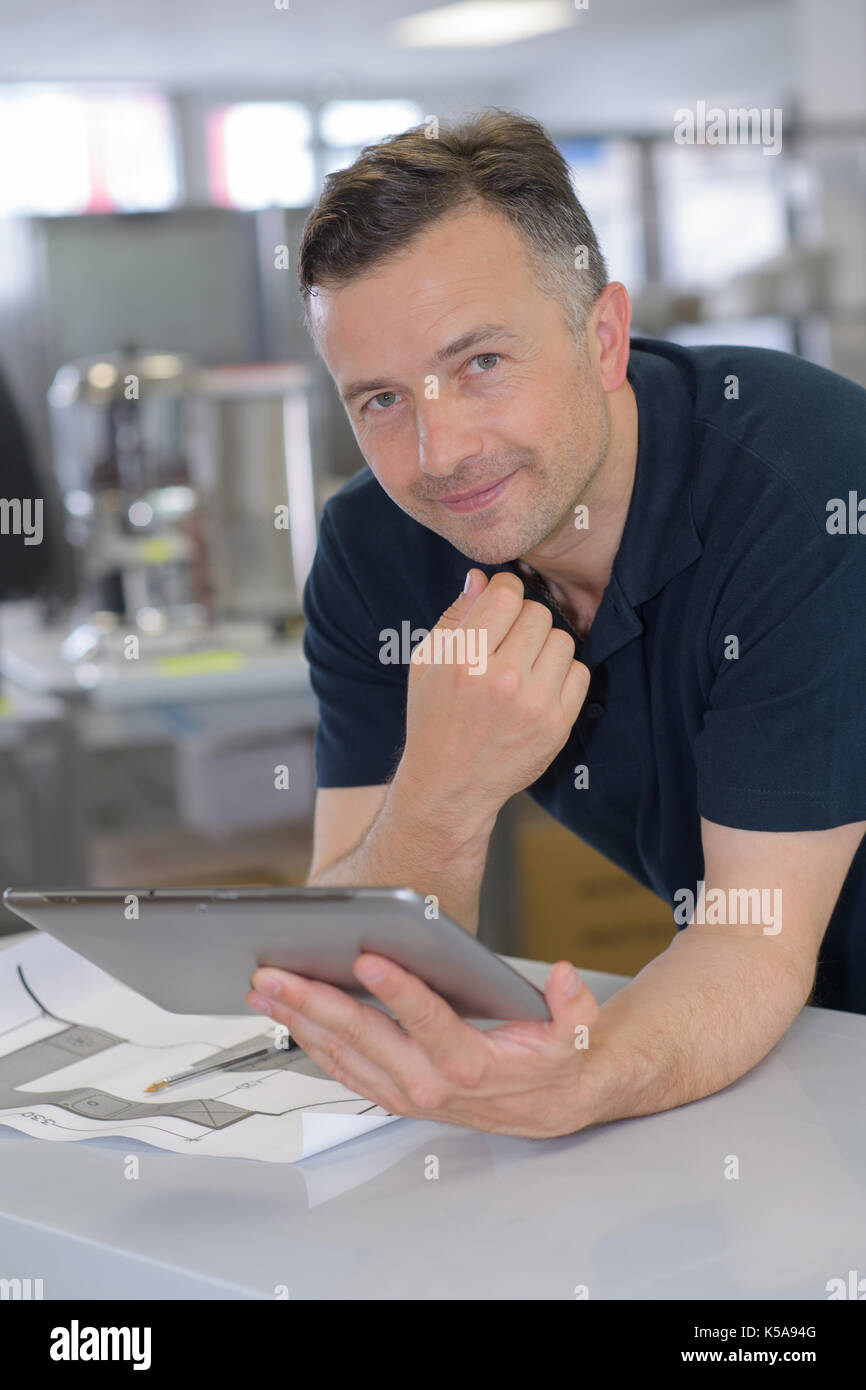 man holding tablet smiling at the camera Stock Photo - Alamy