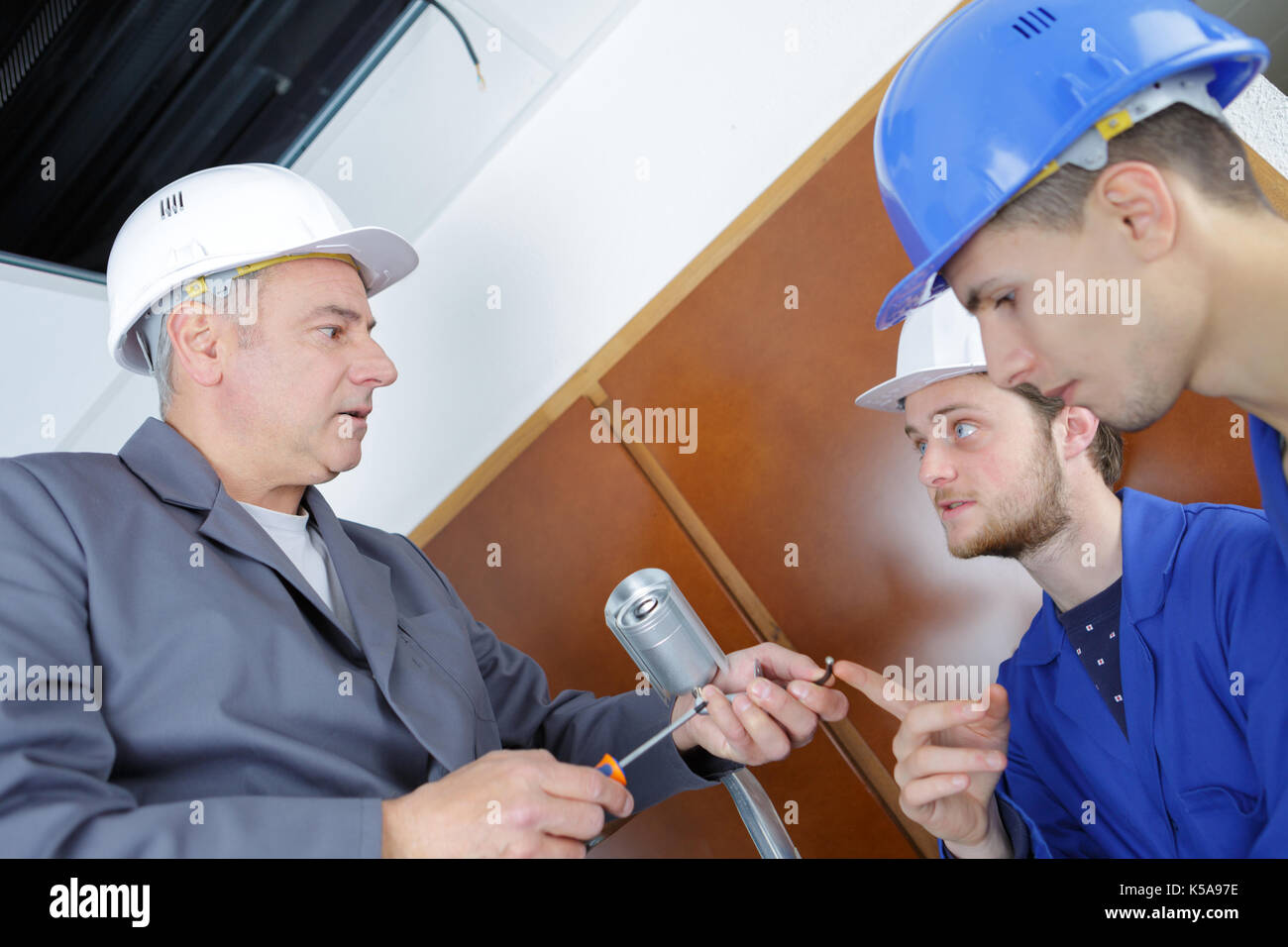 Student questioning instructor holding screwdriver and screws Stock ...