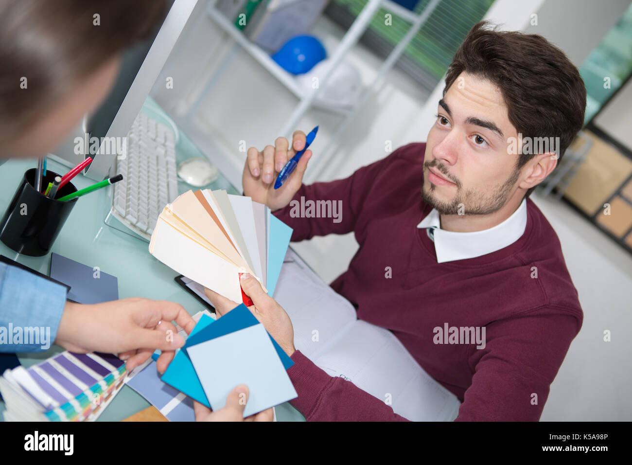 interior designer showing color samples to client in his office Stock ...