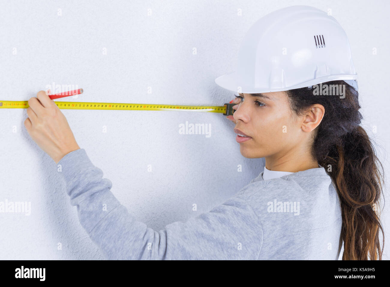 worker measuring wall at construction site Stock Photo - Alamy