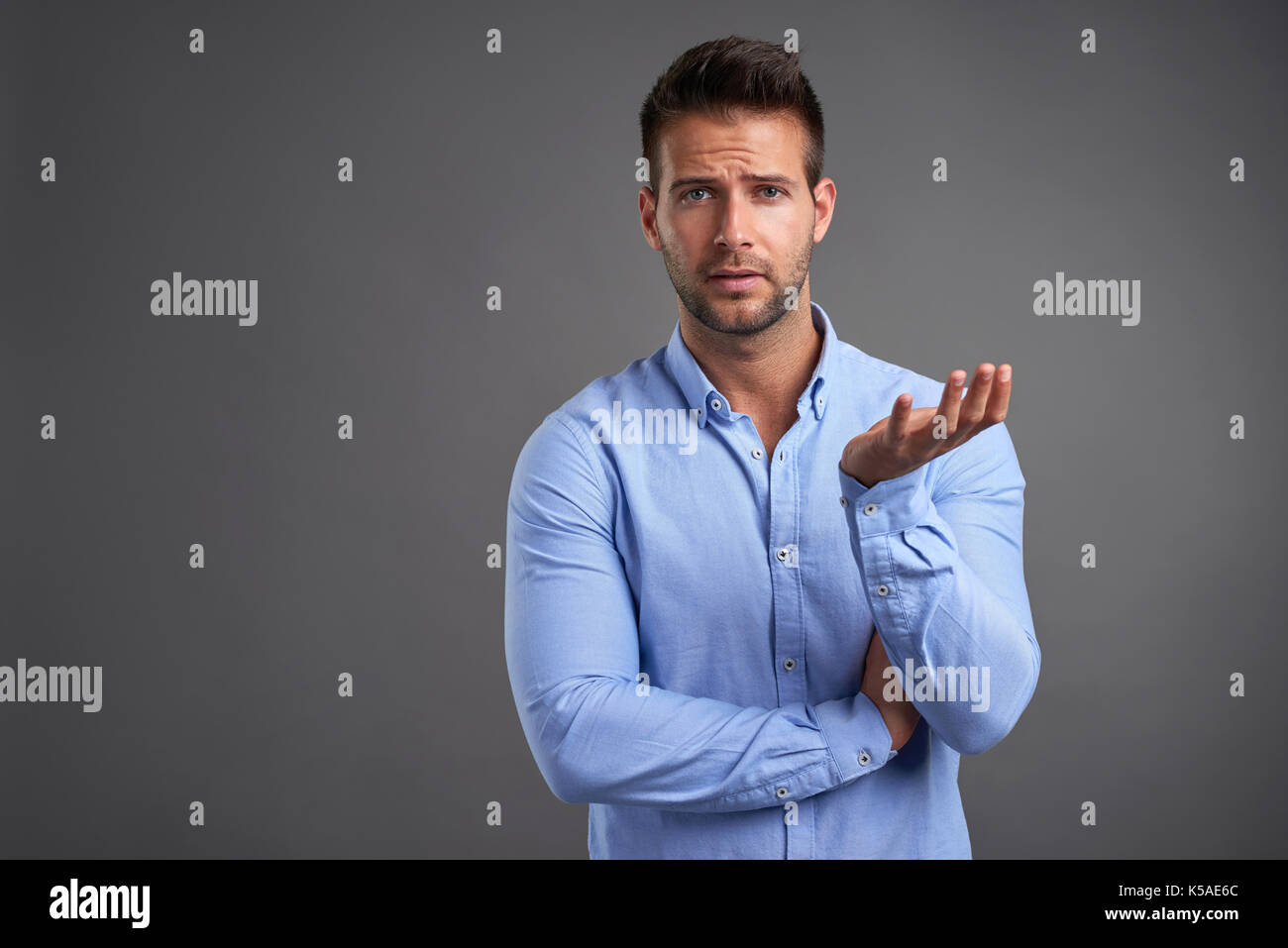 A handsome young man looking uncomprehendingly in to the camera in ...